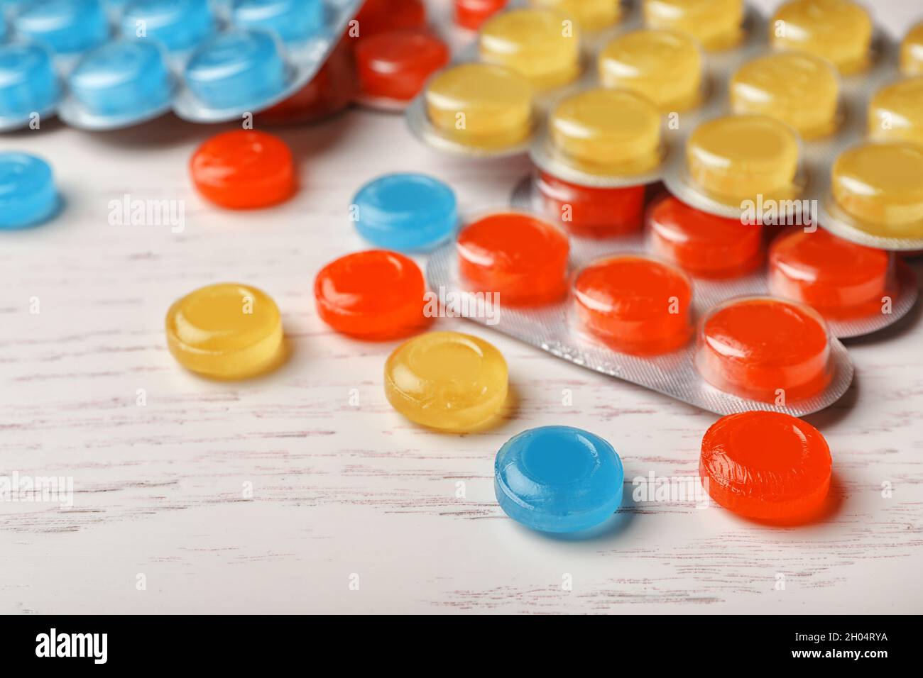Color cough drops on wooden background Stock Photo - Alamy
