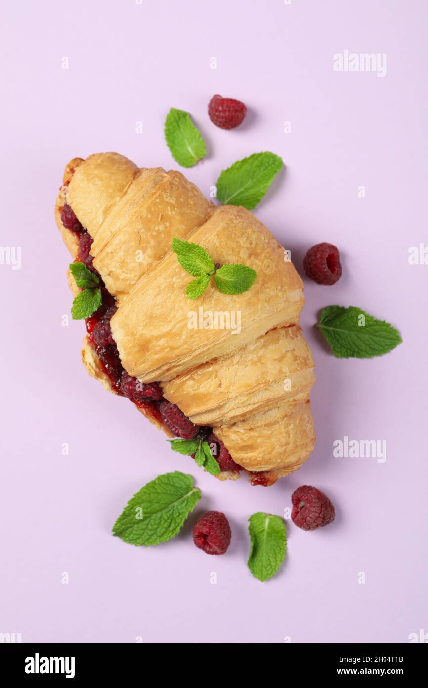 Croissant with raspberry jam on purple background Stock Photo - Alamy