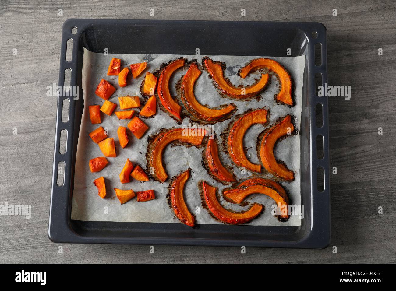 Baking tray with baked pumpkin on gray textured background Stock Photo ...