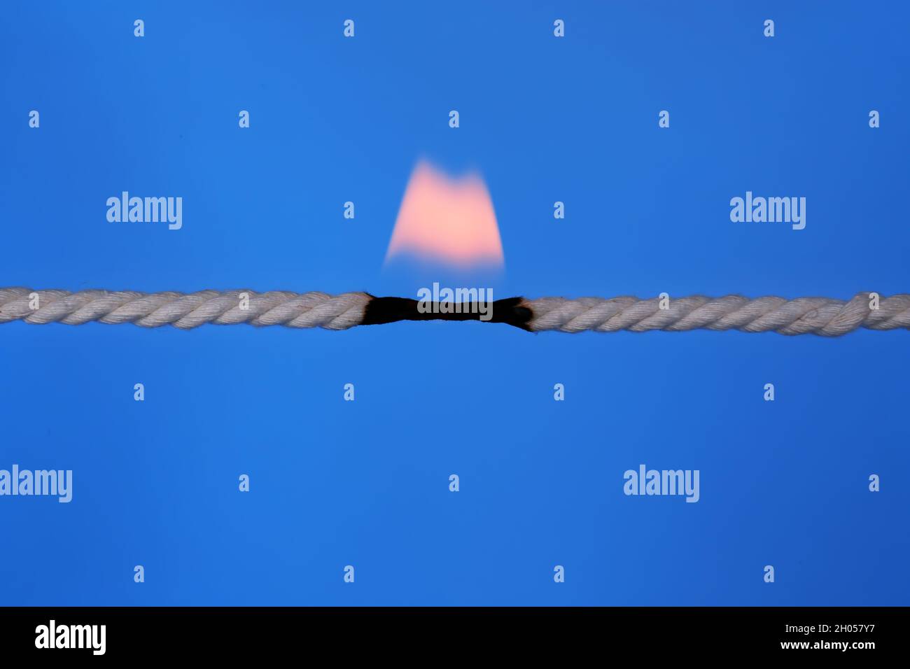 Burning rope at breaking point on color background Stock Photo - Alamy