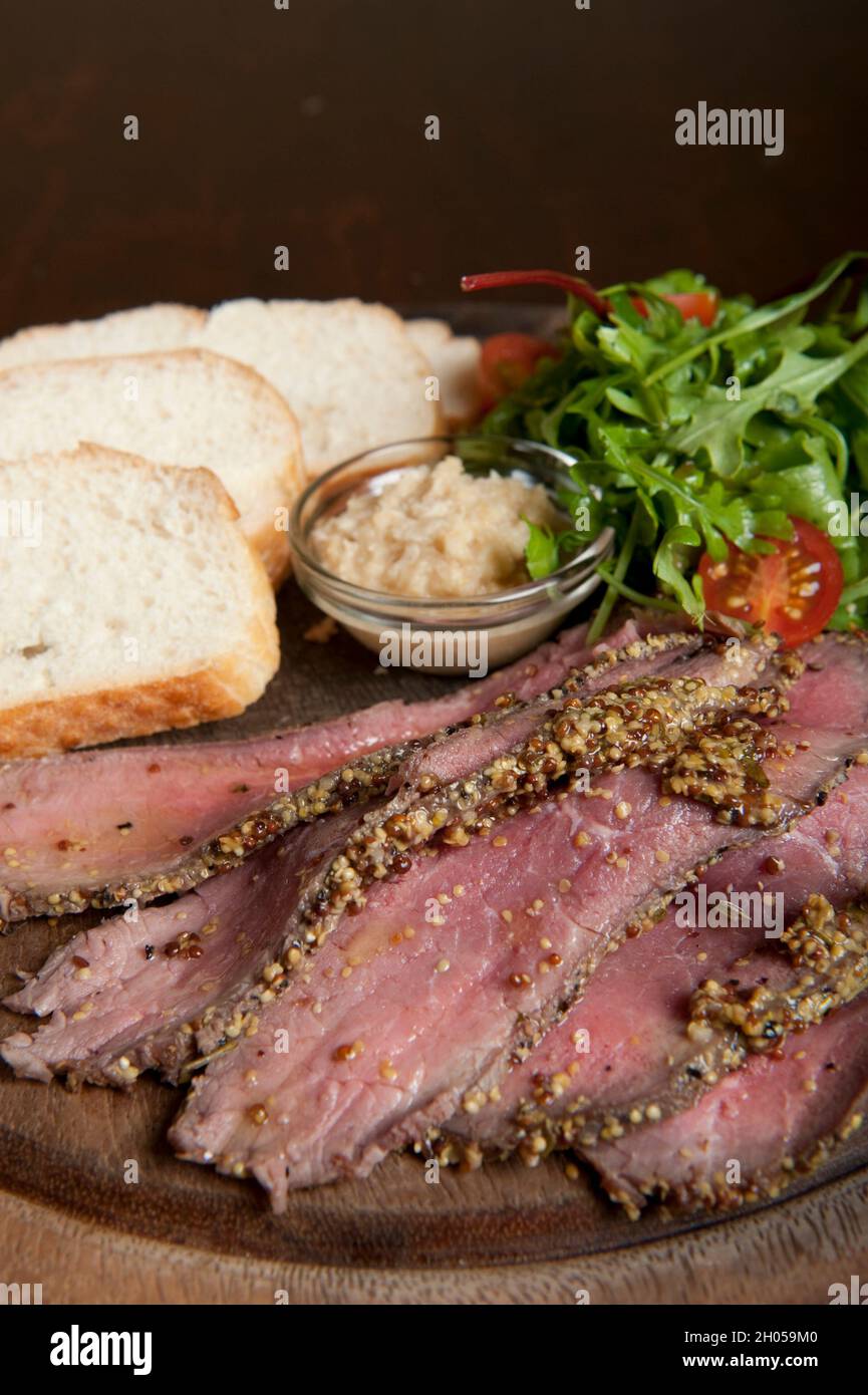 Roast Beef slices and white bread on a wooden platter Stock Photo - Alamy