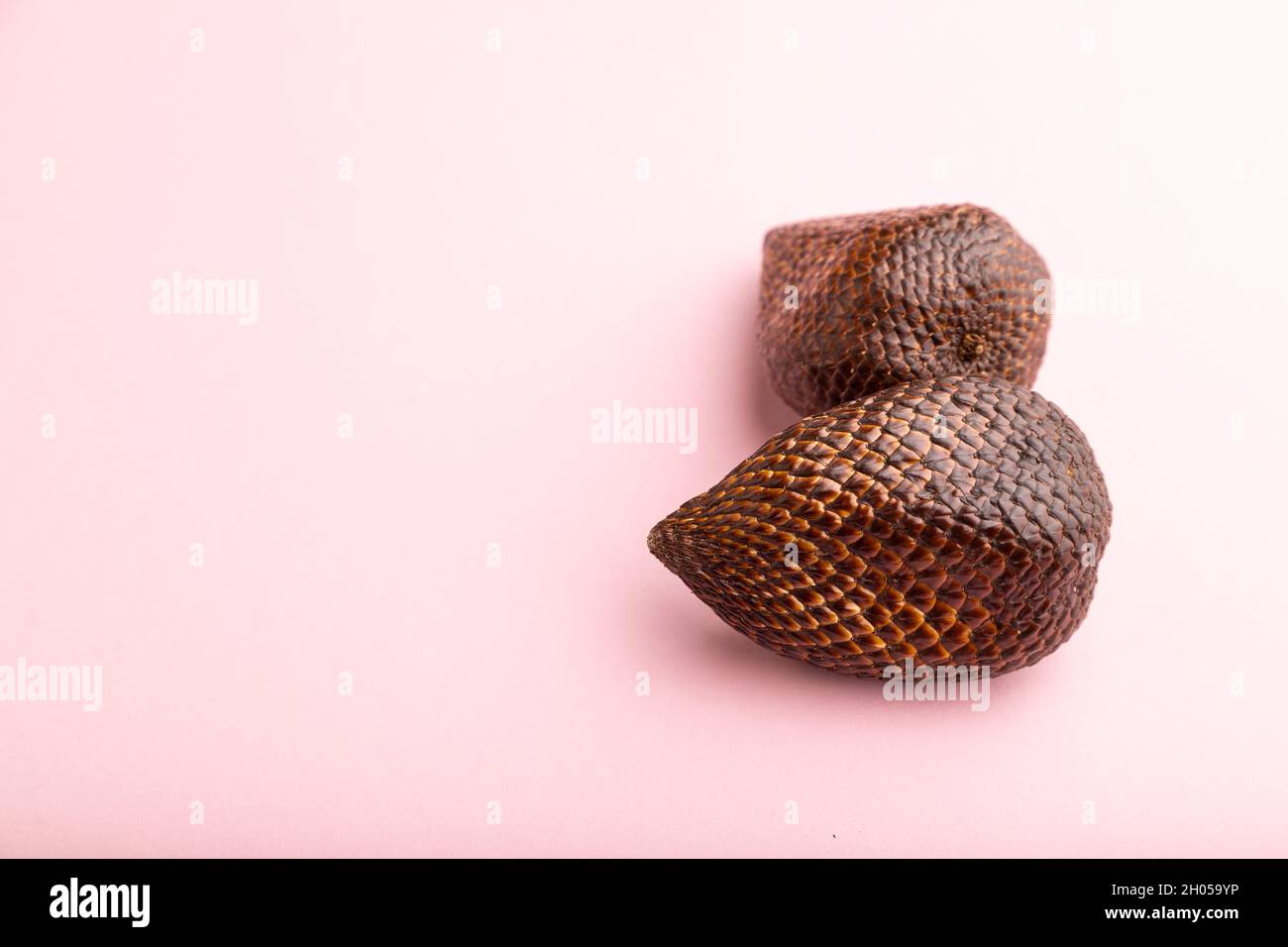 Salak or snake fruit on pink pastel background. Side view, copy space ...