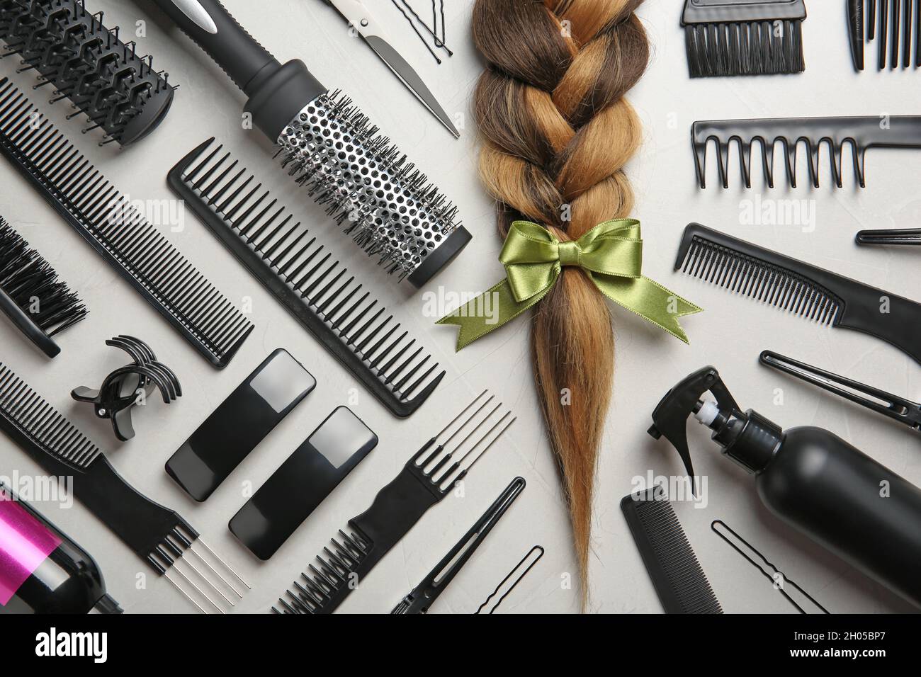 Flat lay composition with braid and hairdresser's tools on gray ...