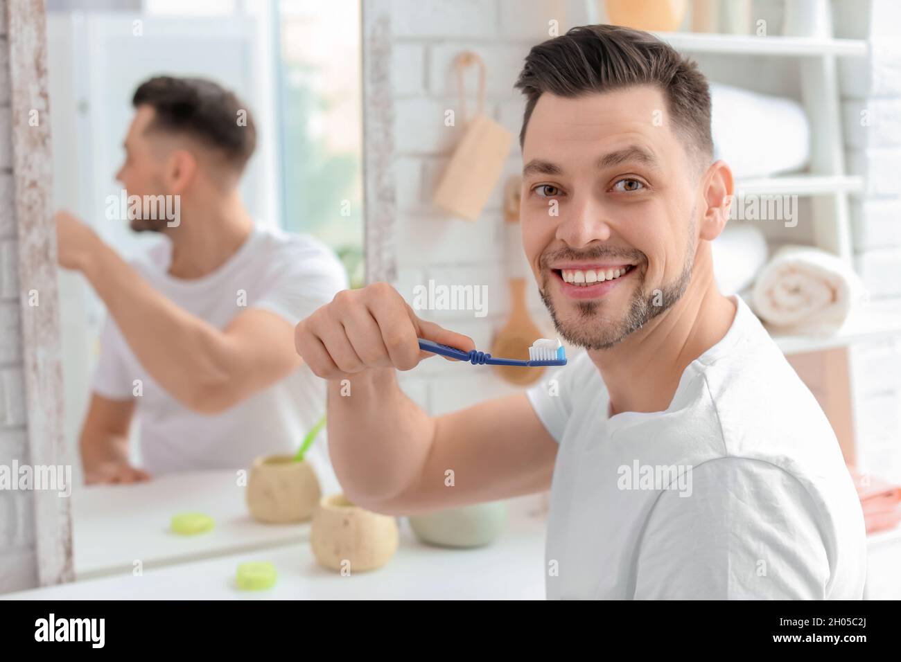 Young man brushing his teeth in bathroom Stock Photo - Alamy