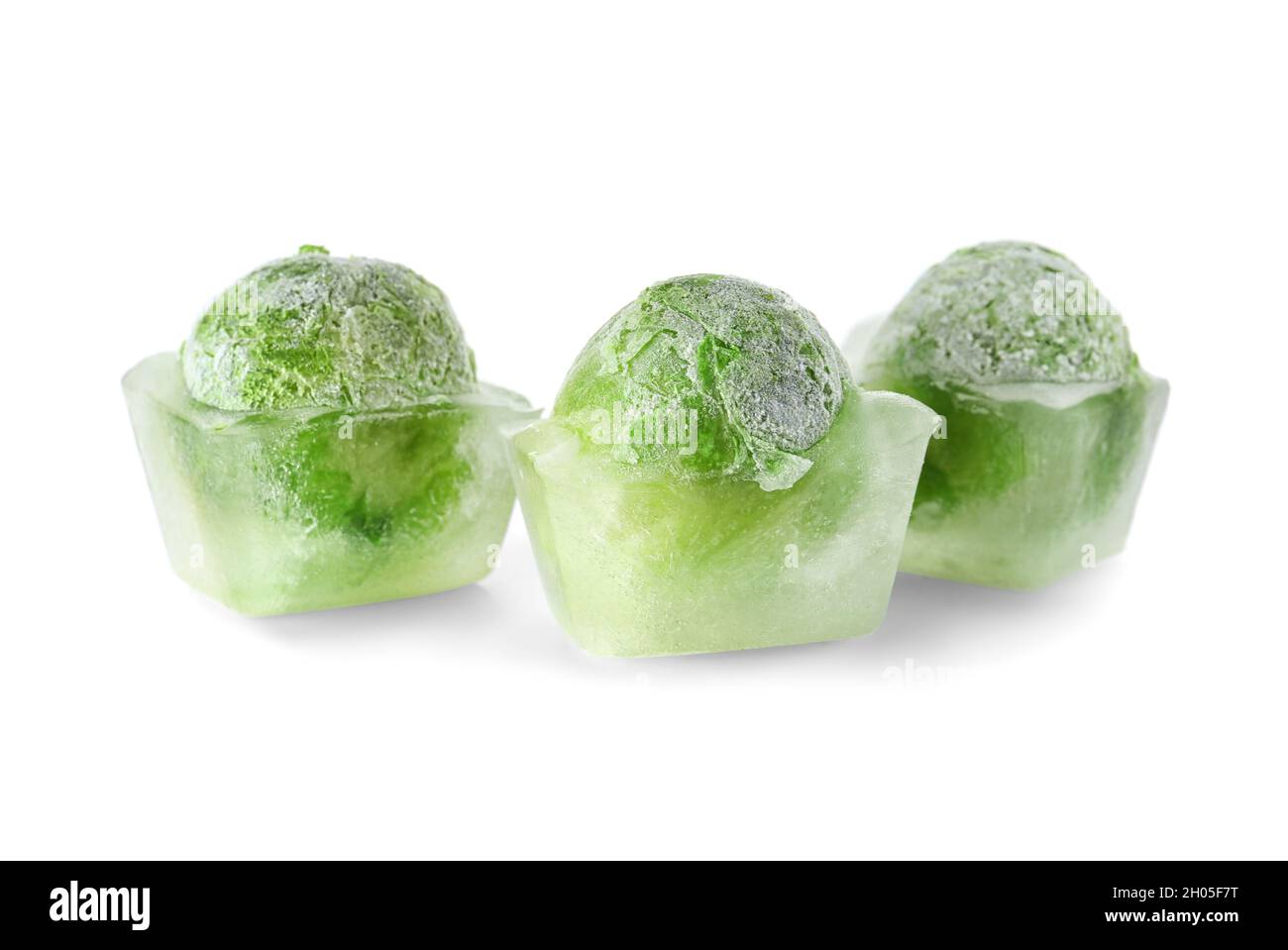 Brussels sprouts in ice cubes on white background. Frozen vegetables ...
