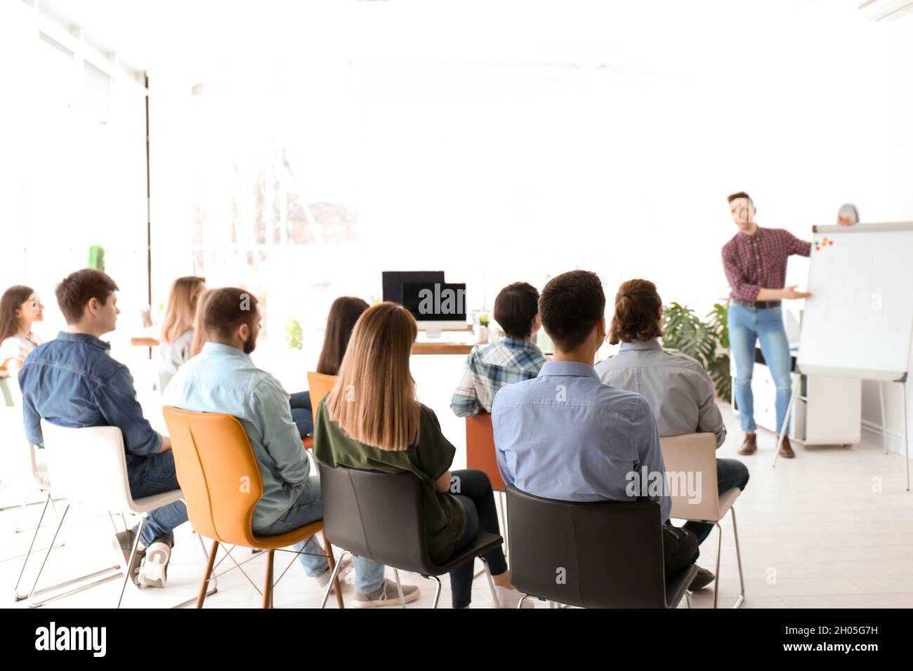 Male business trainer giving lecture in office Stock Photo - Alamy