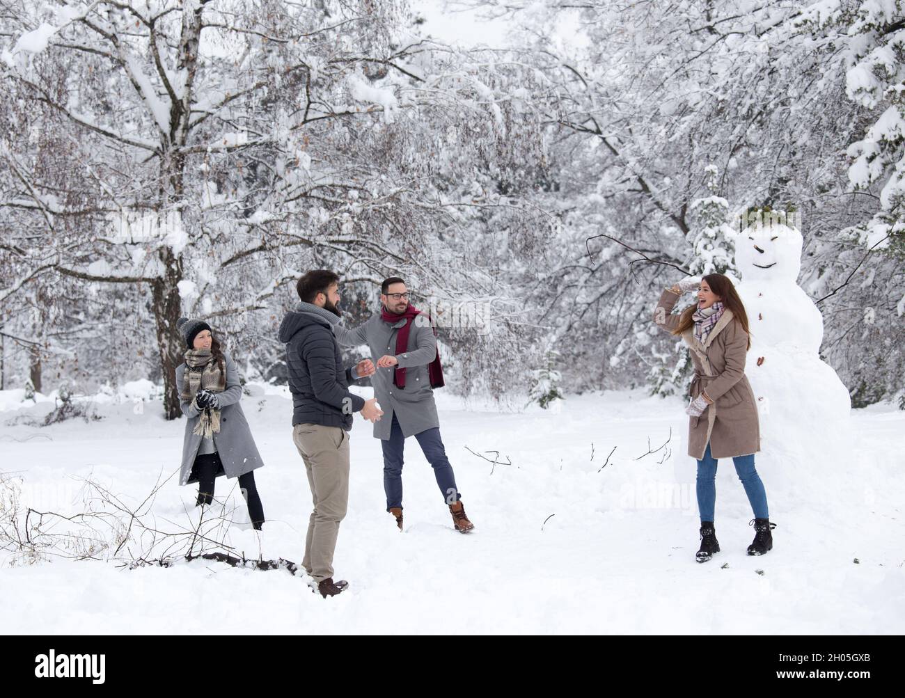 Two couples having fun on snow in park, playing snowball fight Stock ...