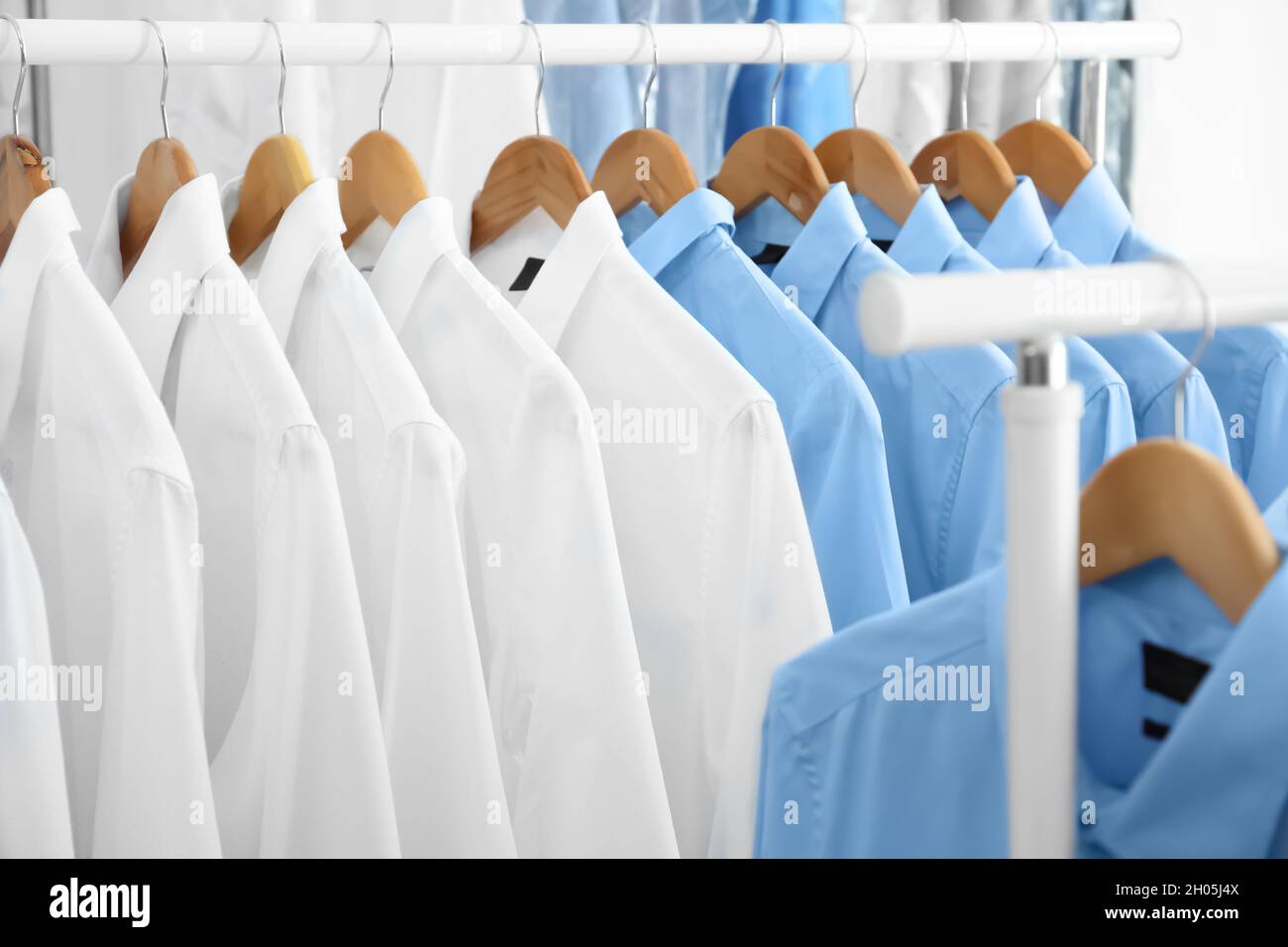Rack with clean clothes on hangers after dry-cleaning indoors Stock ...