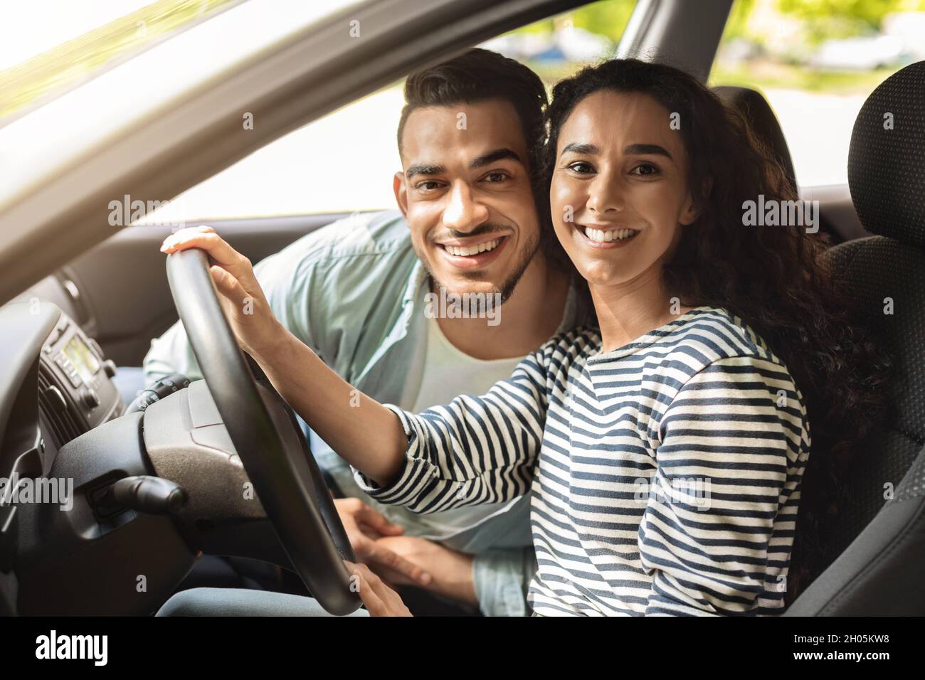 Beautiful young woman driver posing inside new automobile with her ...