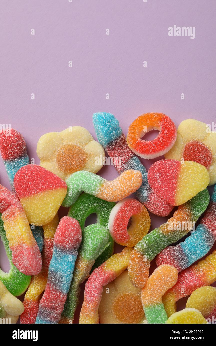 Gummy candies on violet background, space for text Stock Photo - Alamy