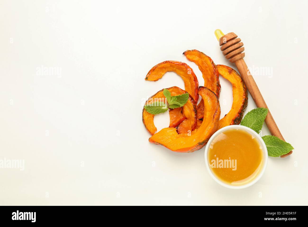 Baked pumpkin, mint, honey and dipper on white background Stock Photo ...