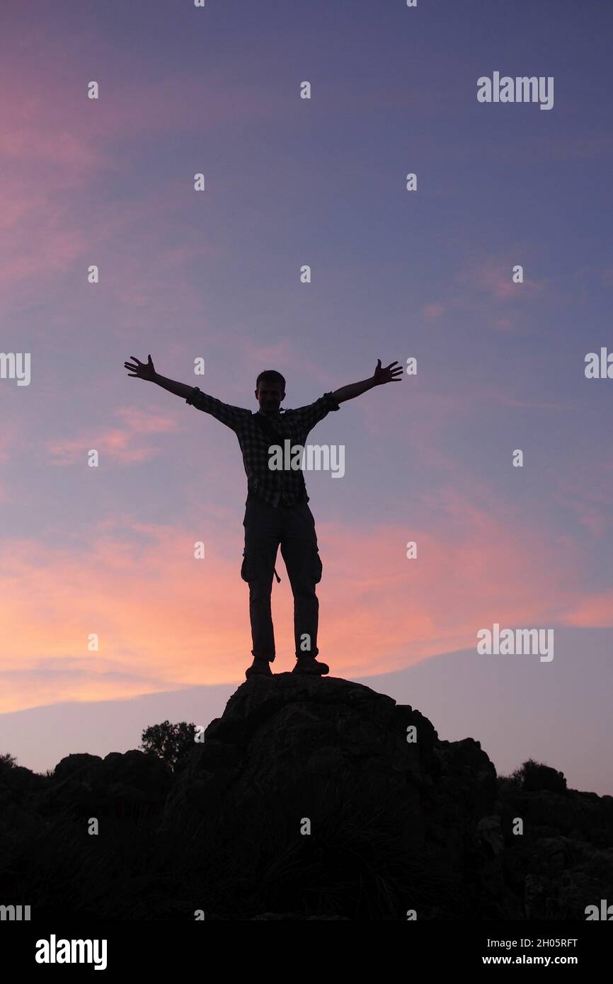 Man standing on the hill with his hands open, feeling the freedom under ...