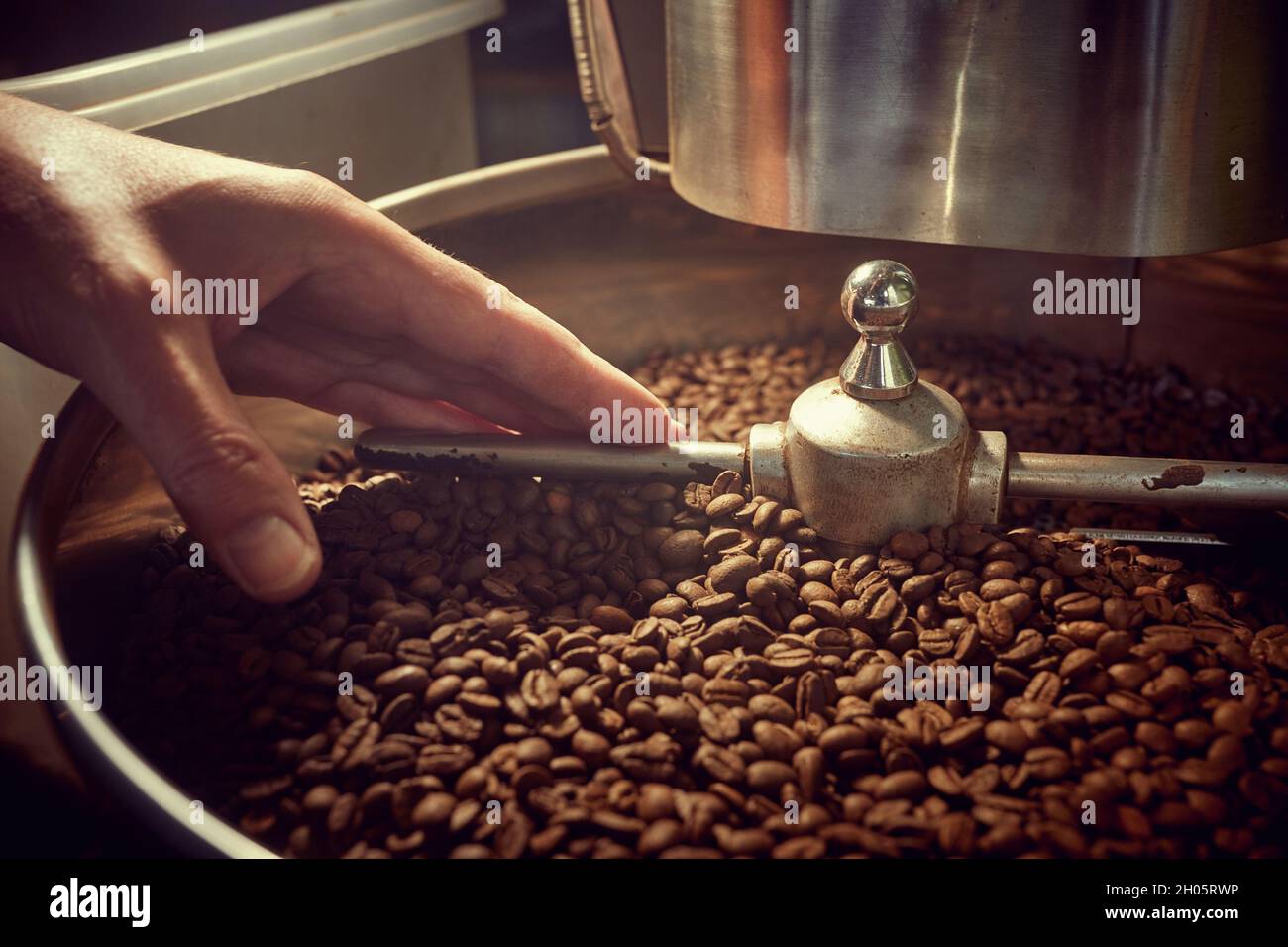 Close up of a worker in coffee roasting process Stock Photo - Alamy