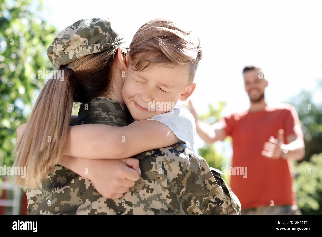 Female soldier hugging with her son outdoors. Military service Stock ...