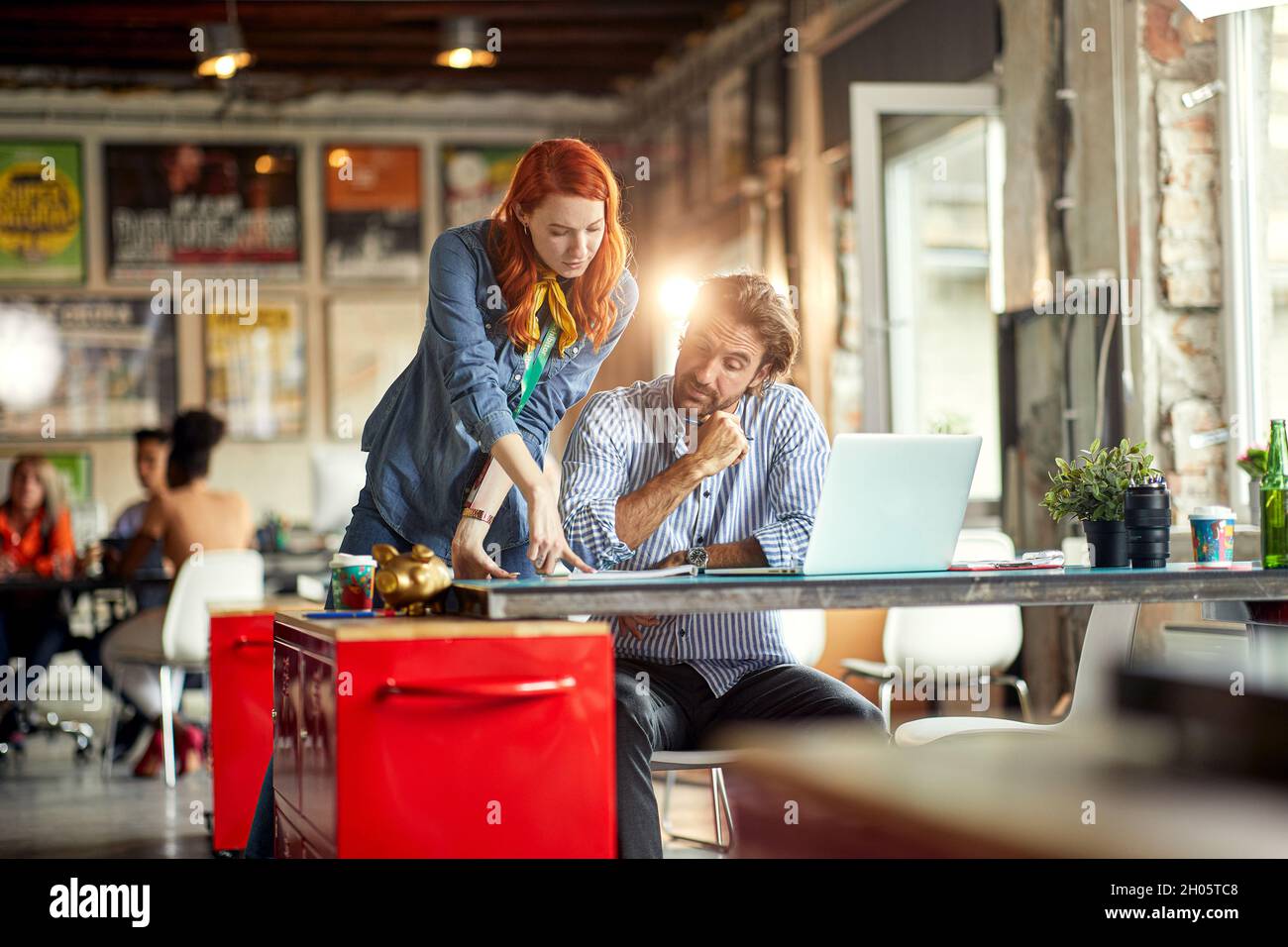 Young colleagues are analyzing documents while working in a pleasant ...