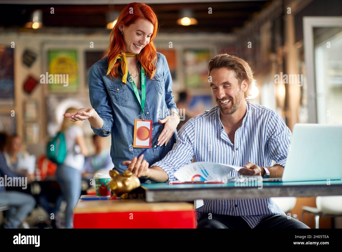 Young colleagues are enjoying while analyzing some documents at work in ...