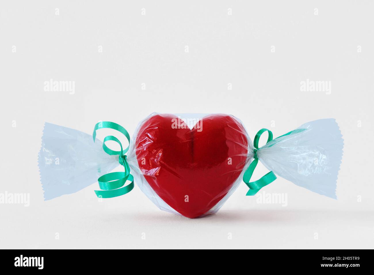 Heart wrapped like candy on white background - Concept of love Stock ...