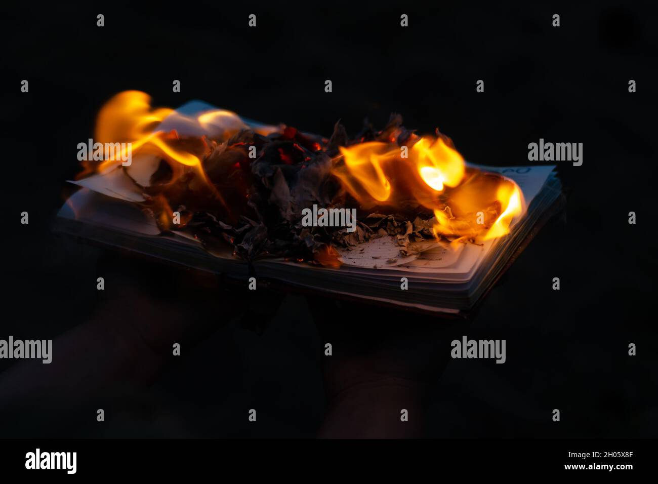 Open burning diary on black background. Notebook with flame coverage ...