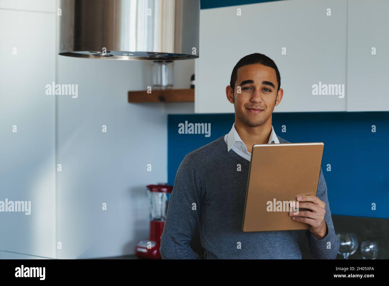 Smart young Black man relaxing in the kitchen looking at camera with ...