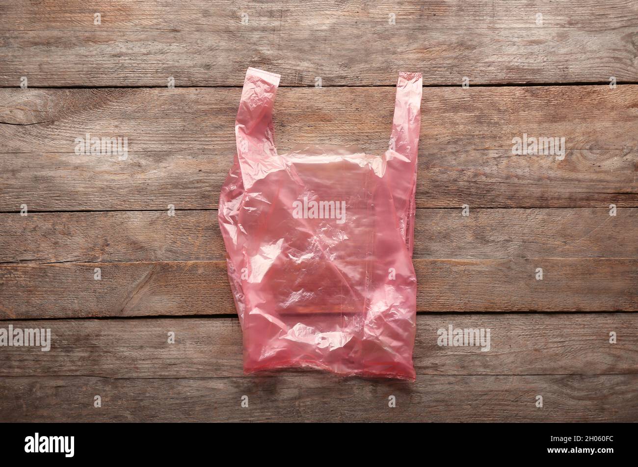 Clear disposable plastic bag on wooden background Stock Photo - Alamy