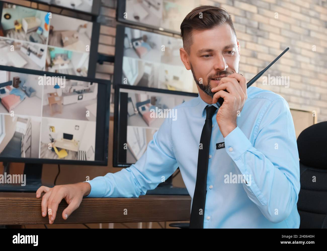 Male security guard with portable transmitter at workplace. CCTV ...