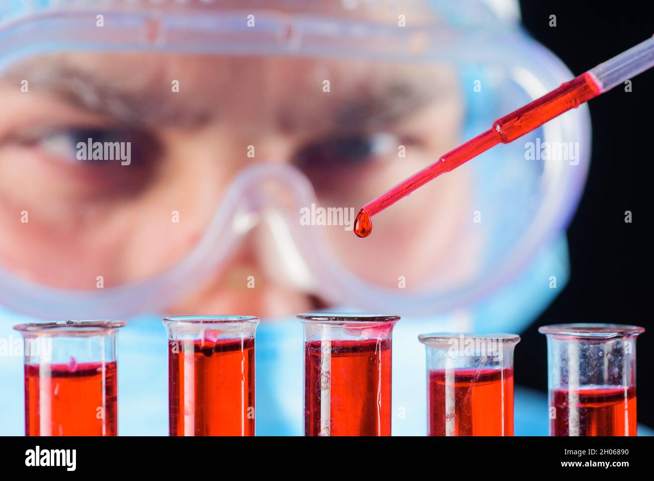 Blood test. Doctor in medical mask and glasses making research in ...