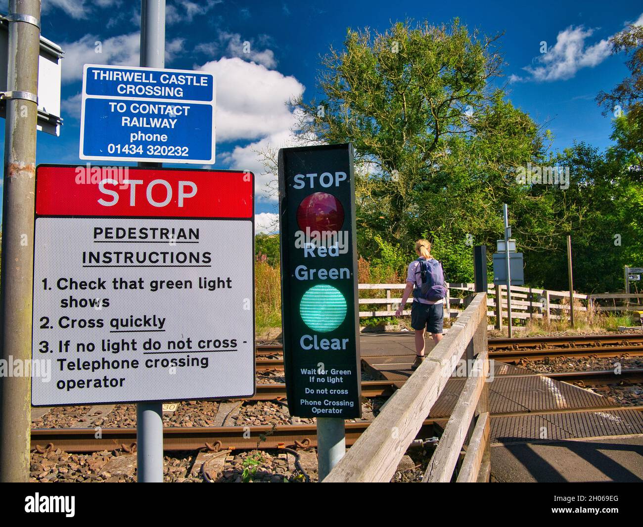 White, red and blue signs warn those crossing the railway to stop and ...