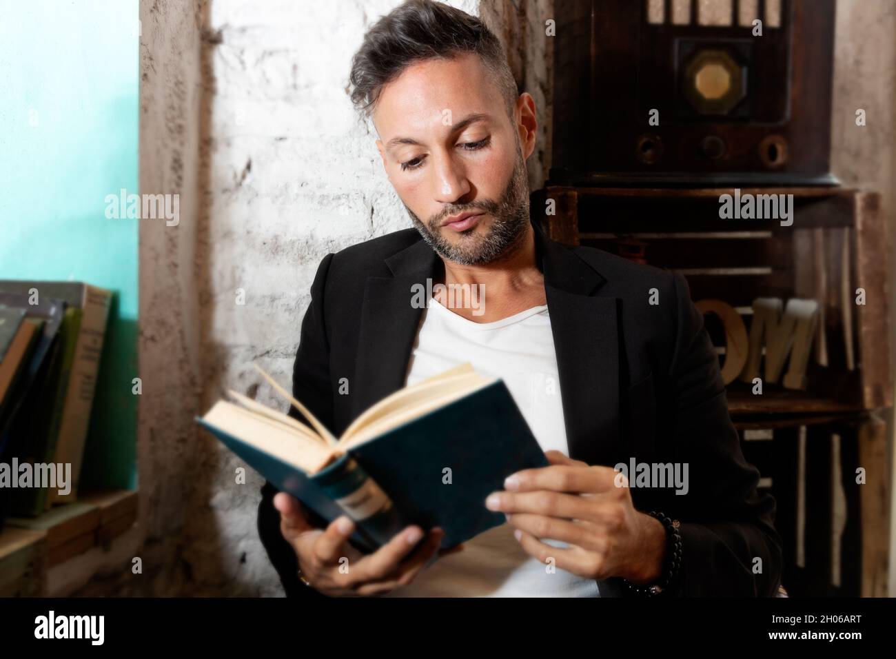 A man reading a book in an urban pub in the city Stock Photo - Alamy