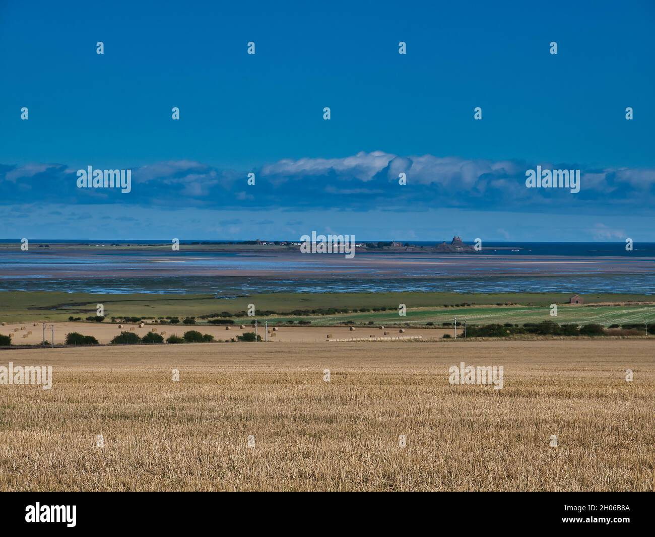 A distant view across fields of Lindisfarne (Holy Island) in ...