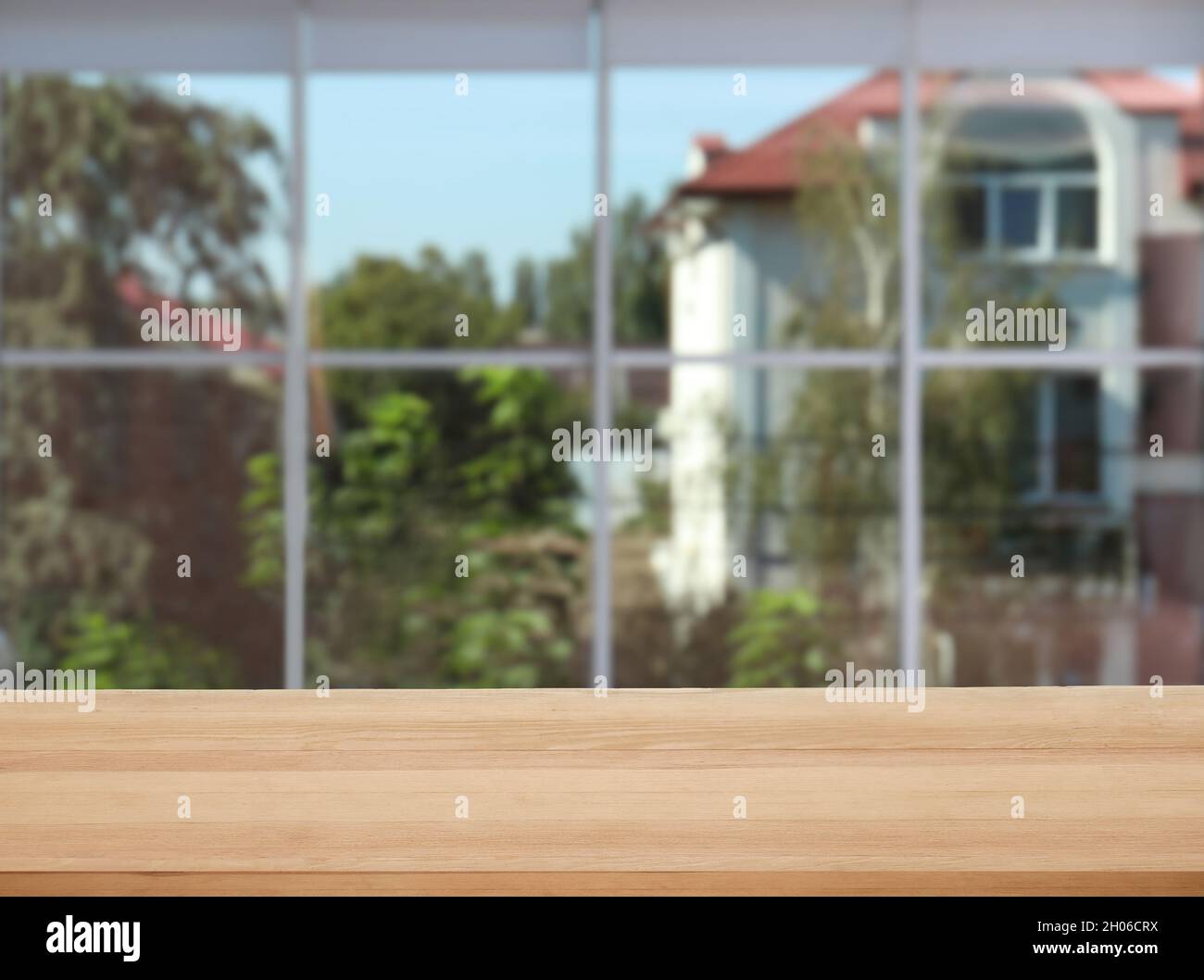 Wooden table in front of big window indoors Stock Photo - Alamy