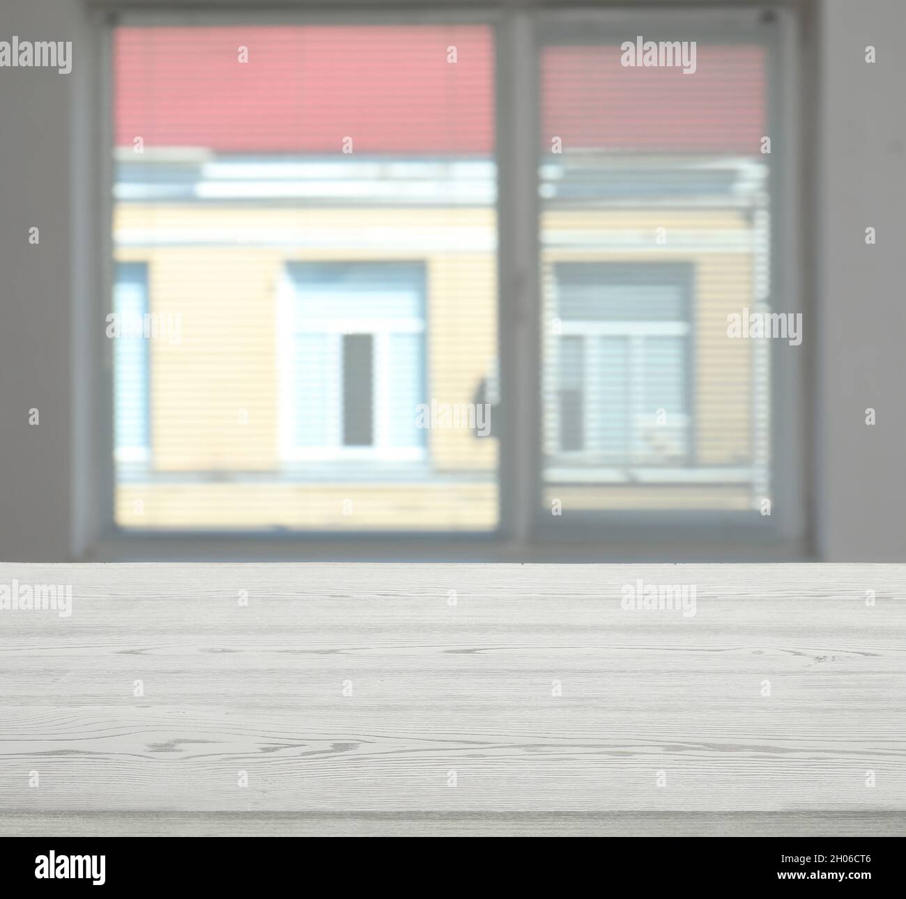 Wooden table in front of window with shutters indoors Stock Photo - Alamy