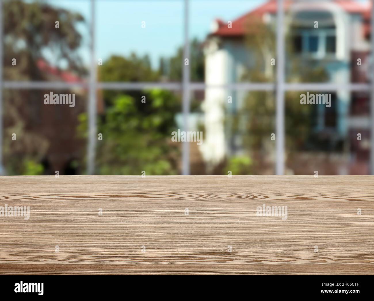 Wooden table in front of big window indoors Stock Photo - Alamy