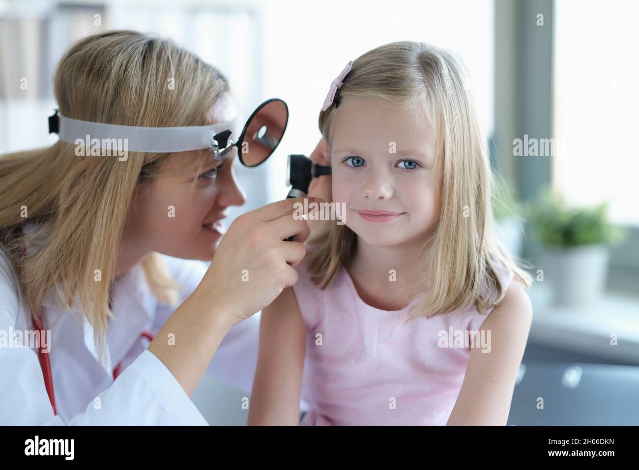 ENT doctor looks at little girl's ears with otoscope closeup Stock ...