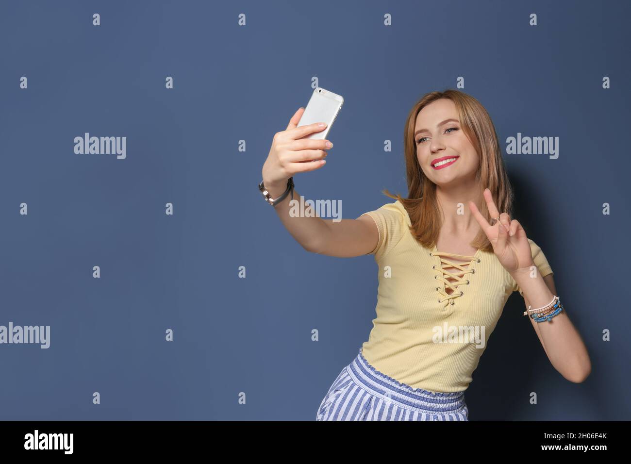 Attractive young woman taking selfie on color background Stock Photo ...