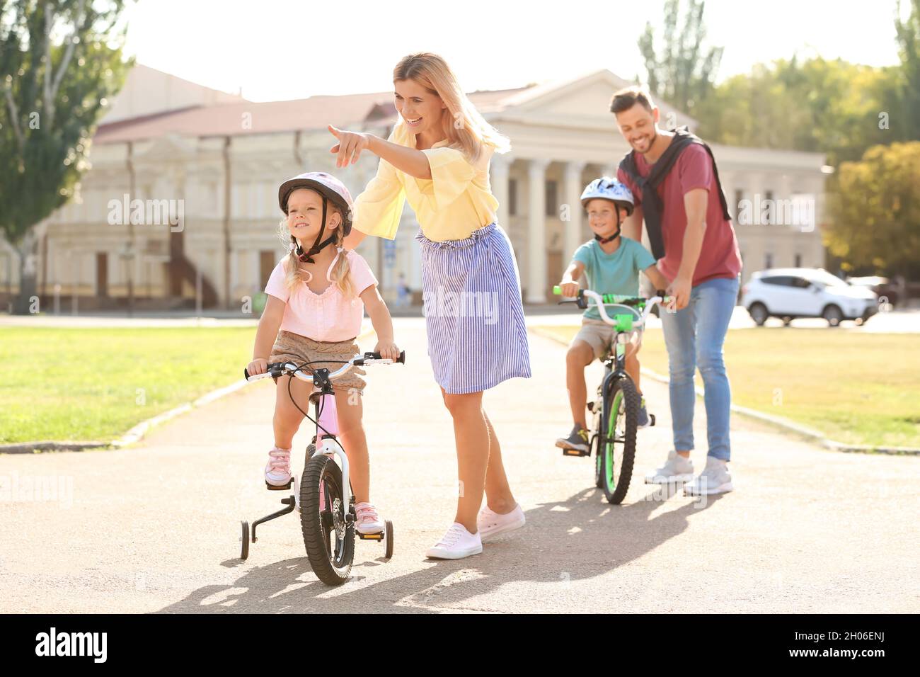 Happy parents teaching children to ride bicycles outdoors Stock Photo ... Happy parents teaching children to ride bicycles outdoors Stock Photo ...