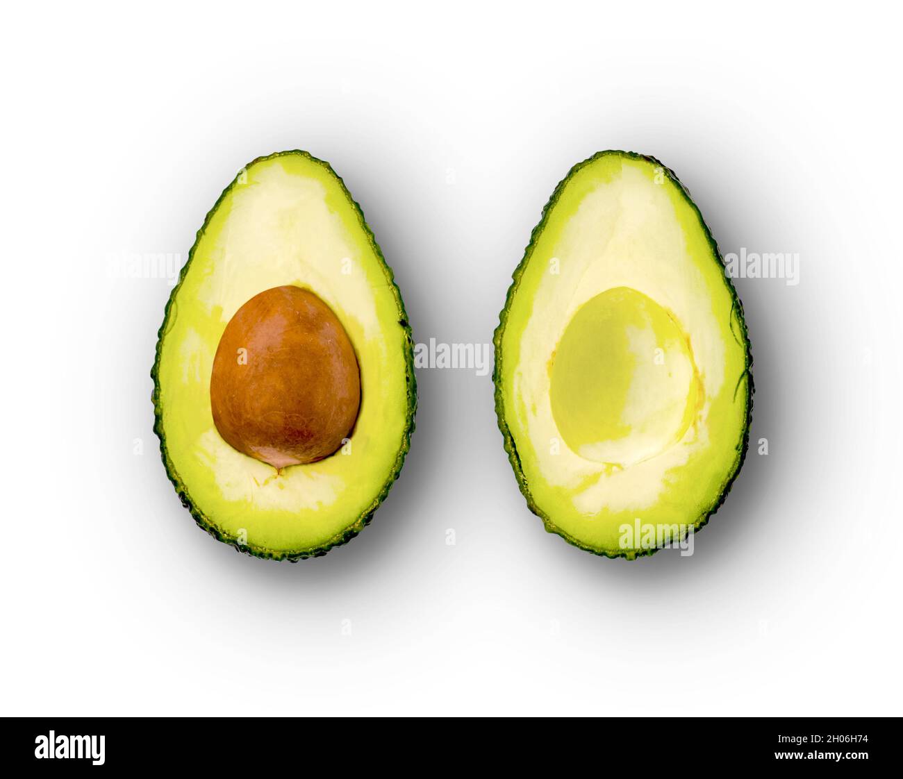 Avocado cut in half on white background Stock Photo - Alamy