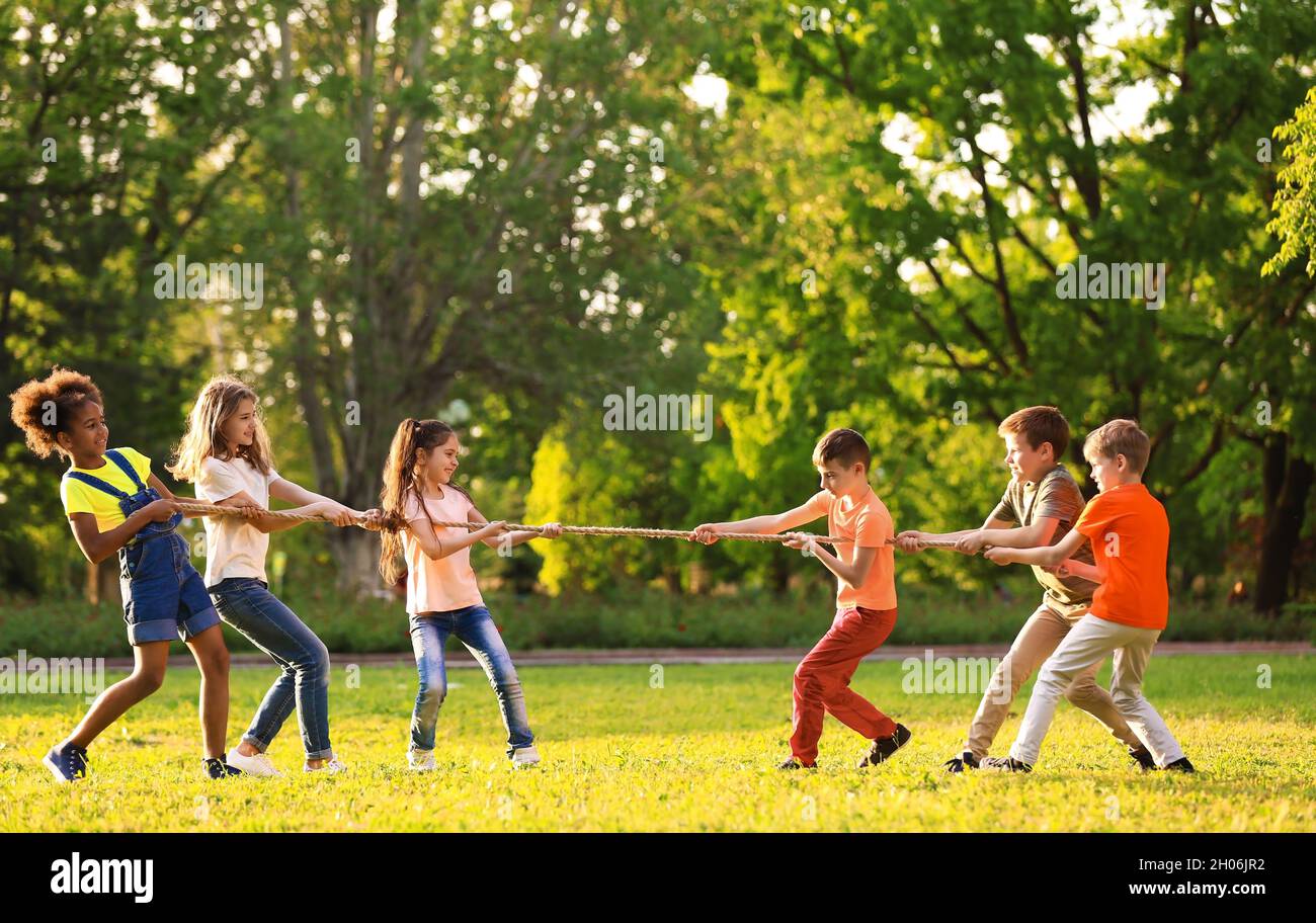 Cute little children playing with rope outdoors on sunny day Stock ...