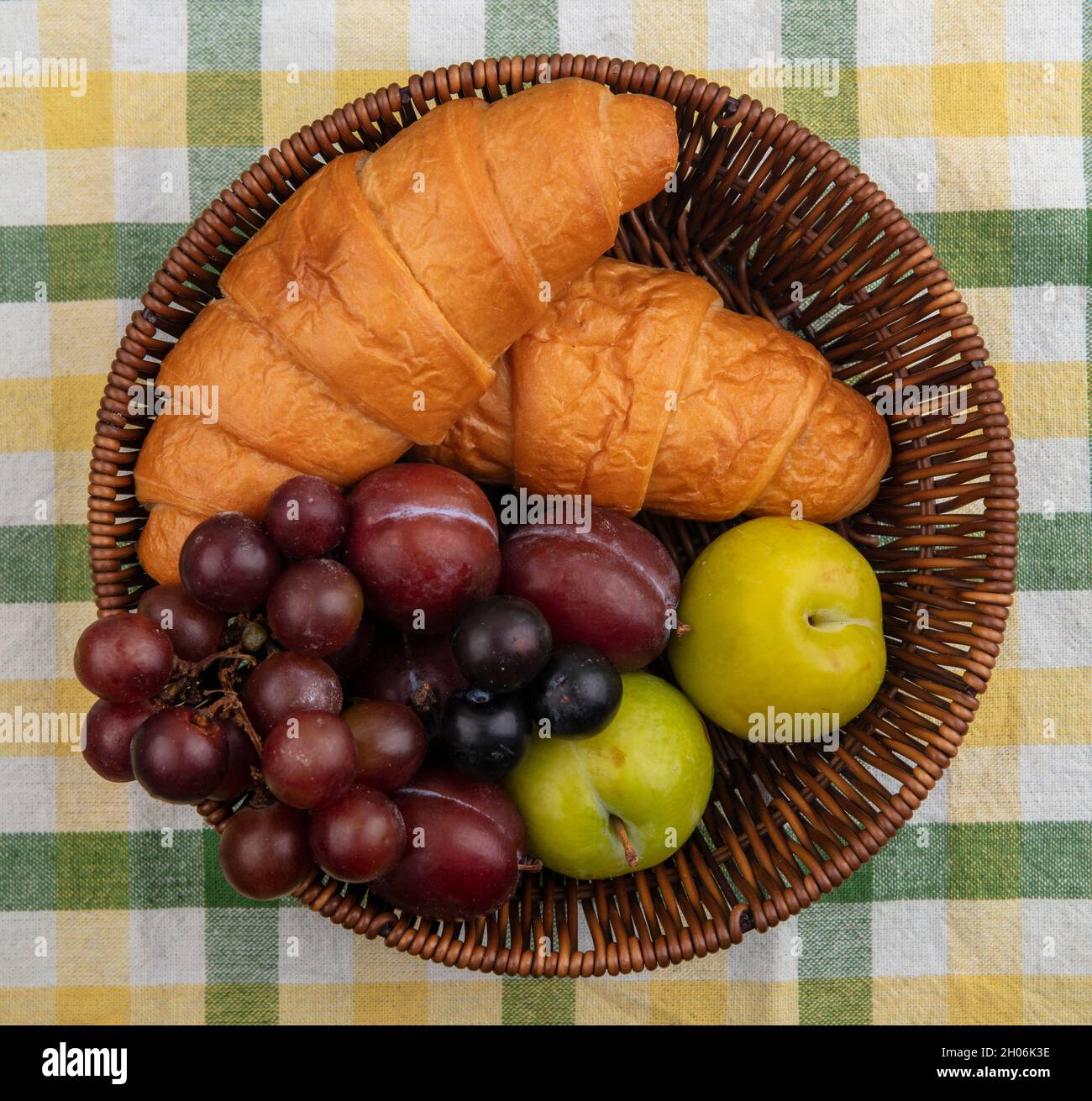 top view of fruits as grape pluots sloe berries with croissants in ...