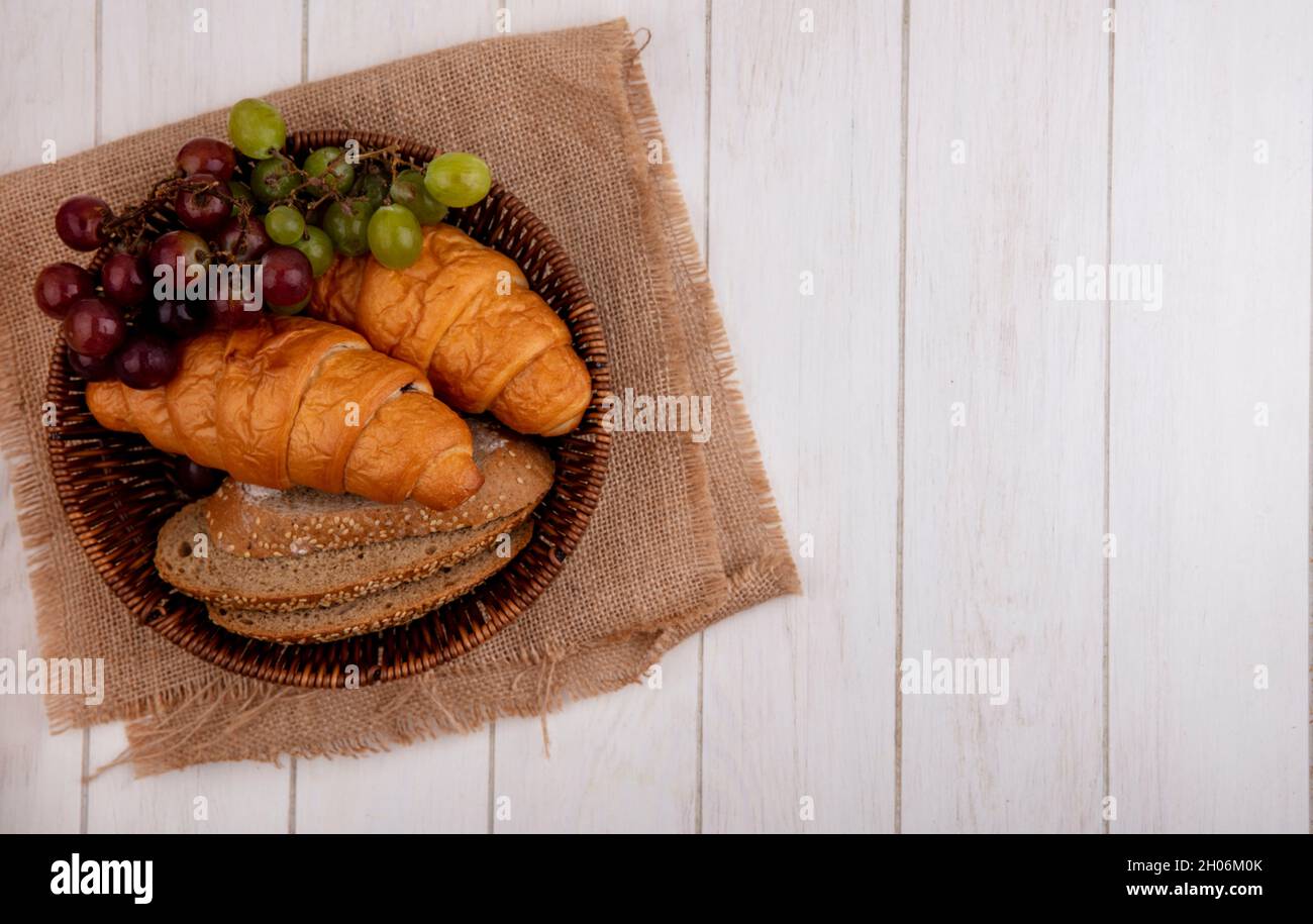 top view of breads as croissant and seeded brown cob bread slices with ...