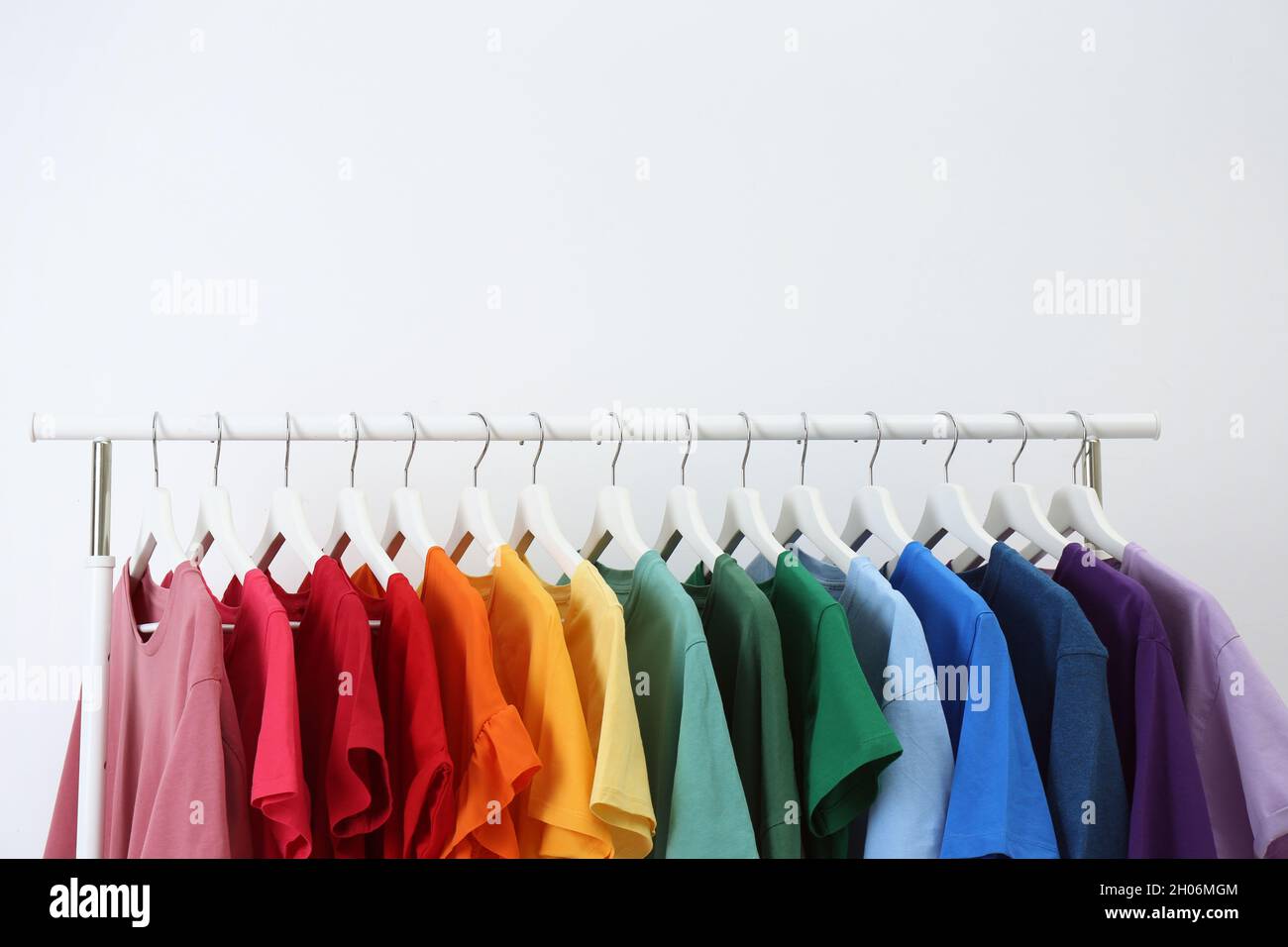 Rack with bright clothes on white background. Rainbow colors Stock ...
