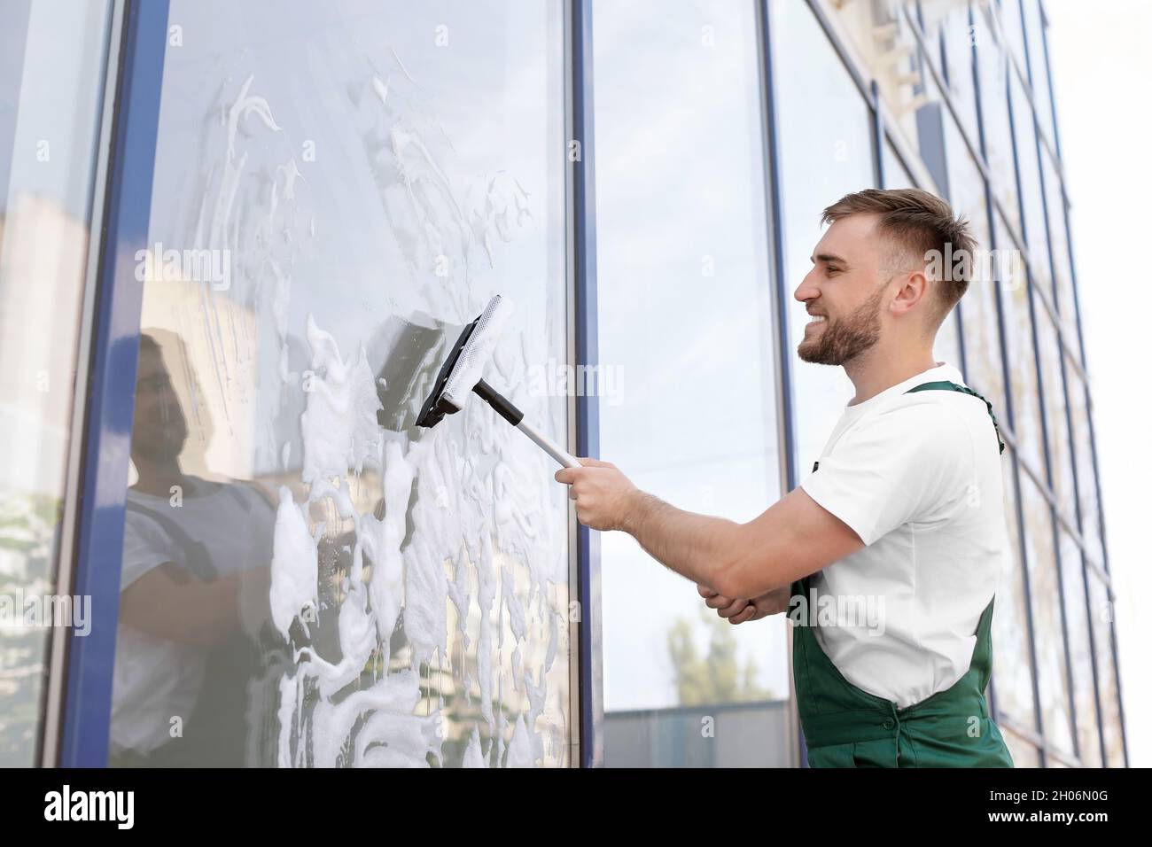 Male cleaner wiping window glass with squeegee from outside Stock Photo ...