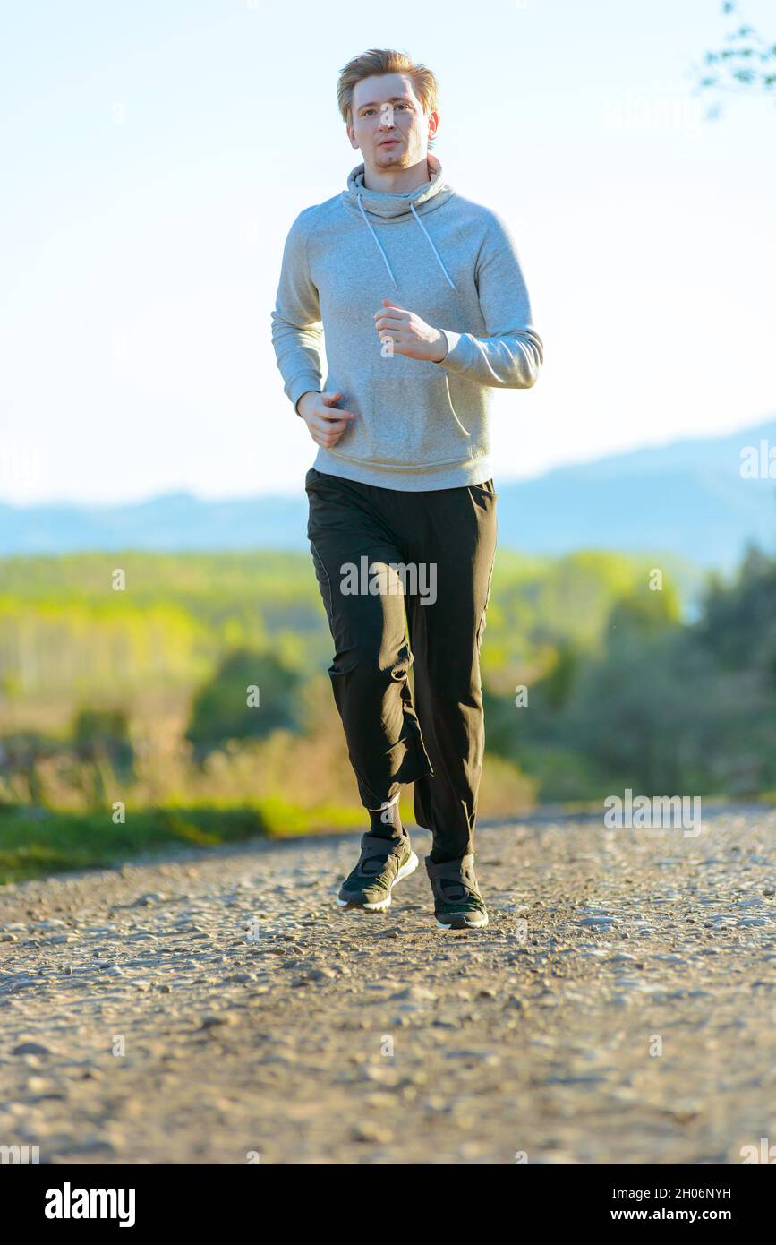 Running man jogging in rural nature at beautiful summer day. Sport ...