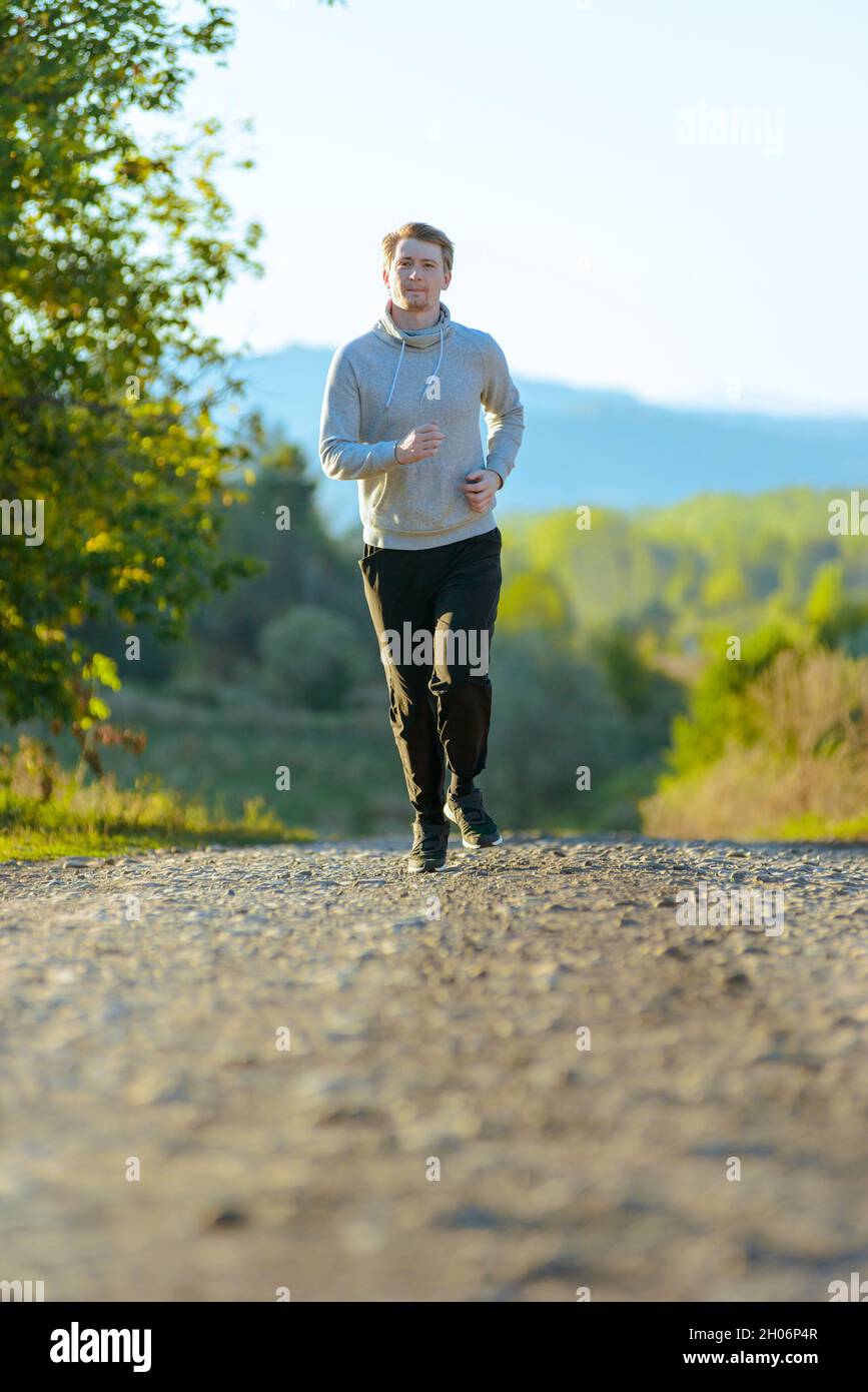 Running man jogging in rural nature at beautiful summer day. Sport ...