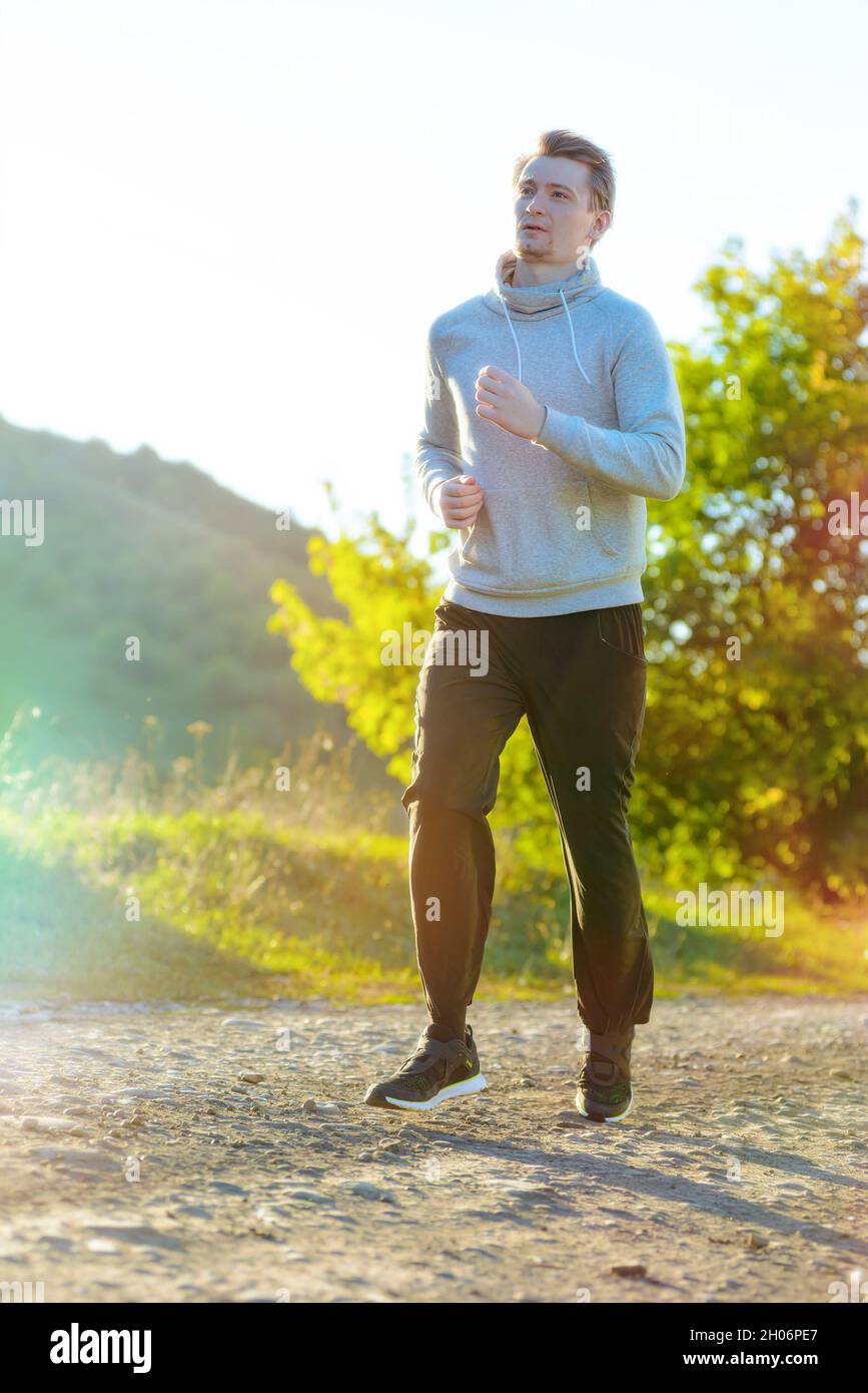 Running man jogging in rural nature at beautiful summer day. Sport ...