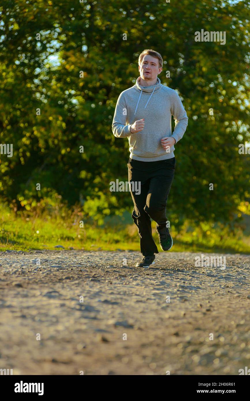 Running man jogging in rural nature at beautiful summer day. Sport ...