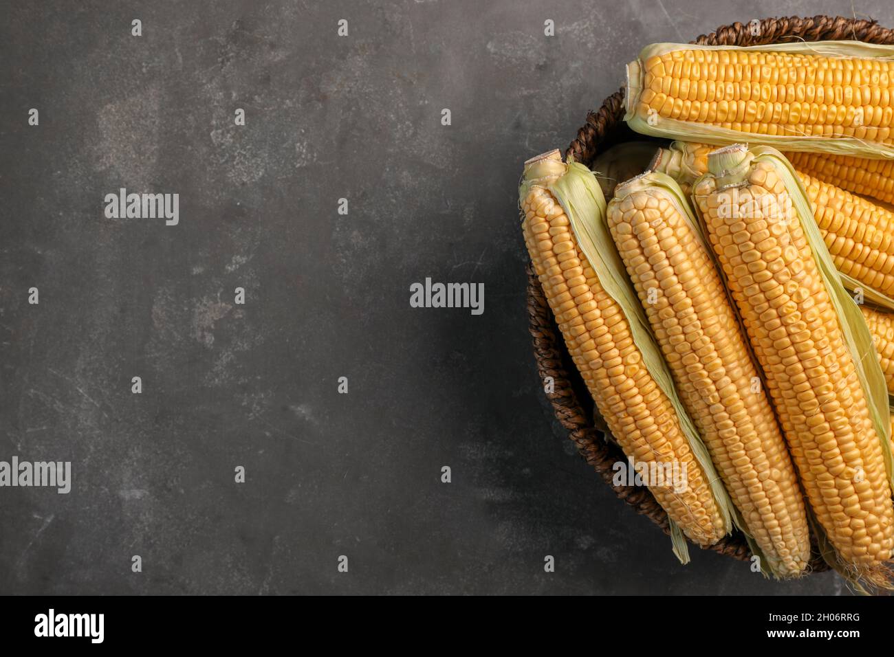 Basket with tasty sweet corn cobs on grey background, top view Stock ...