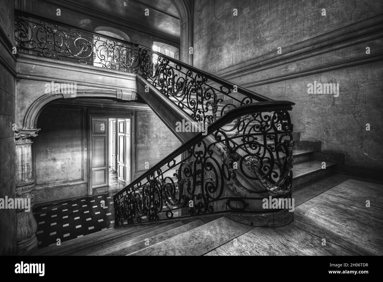 Grayscale of a old-fashioned staircase between two floors of a house ...