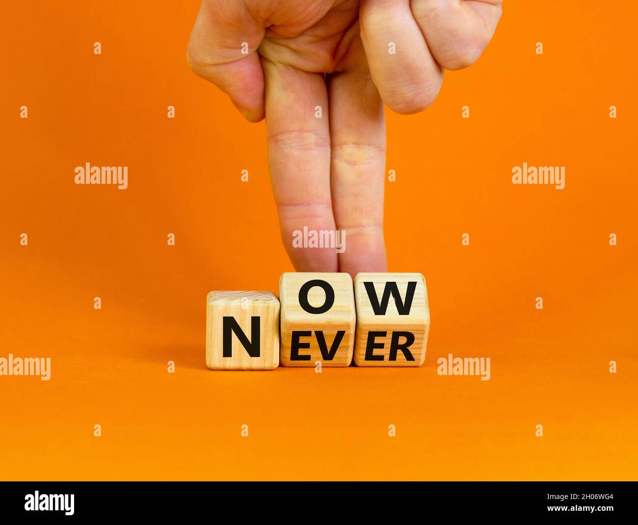 Now or never symbol. Businessman turns wooden cubes and changes the ...