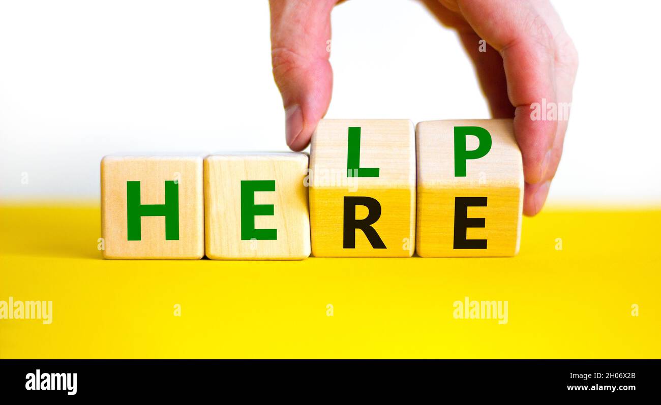 Help is here symbol. Businessman turns cubes and changes the word help ...