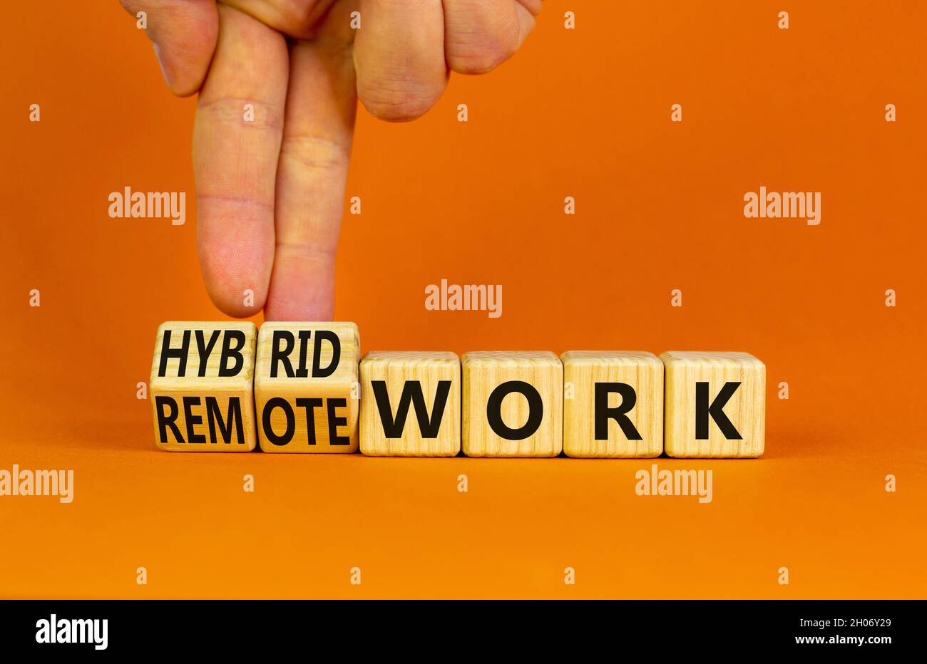 Hybrid or remote work symbol. Businessman turns cubes and changes words ...